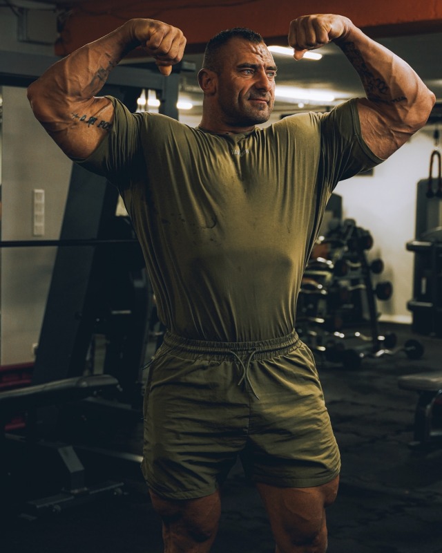 The Muscle God Flexes His Powerful Biceps Slowly Looking Across The Room To See You Staring He